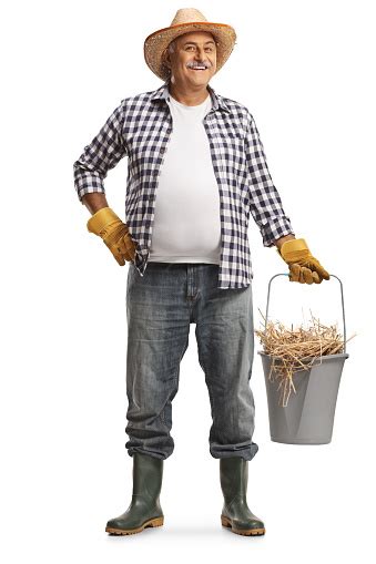 건초로 가득 찬 양동이를 들고 미소 짓는 성숙한 농부의 전체 길이 Potrait 60 64세에 대한 스톡 사진 및 기타 이미지