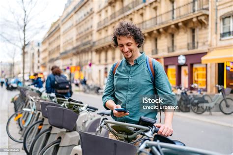 프랑스 파리에서 전화를 사용하여 전기 자전거를 대여하는 중년 남성 Bicycle Parking Station에 대한 스톡 사진 및 기타 이미지 Bicycle