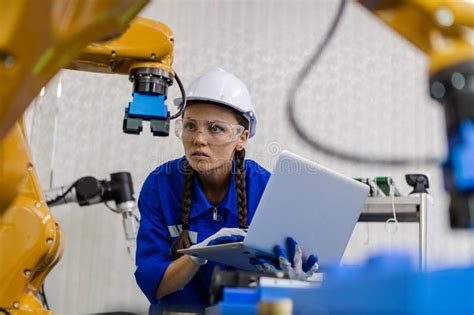 Female Technician Engineer Using Laptop Checking Automation Robotics At Industrial Modern