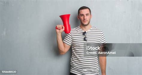 스마트 얼굴 심각한 생각에 자신감 표현 물마루 확성기 소리 회색 그런 지 벽에 젊은 백인 남자 감정에 대한 스톡 사진 및 기타 이미지 Istock