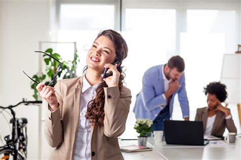 비즈니스 여자 는 백그라운드에서 Colegues와 사무실에서 휴대 전화를 Usiing 귀여운에 대한 스톡 사진 및 기타 이미지 귀여운 기업 비즈니스 낮 Istock