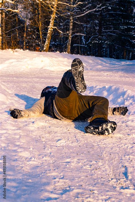 Person Laying On His Back In The Snow After Falling Down Because Of The