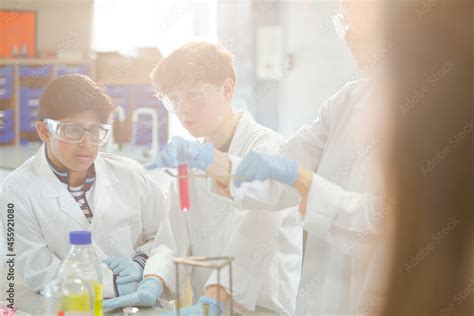 Female Teacher And Babes Examining Liquid In Test Tube Conducting Scientific Experiment In