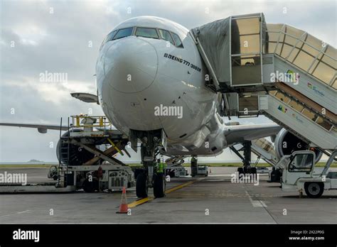 Front View Of A Boeing 777 Airplane With A Boarding Bridge Parked On