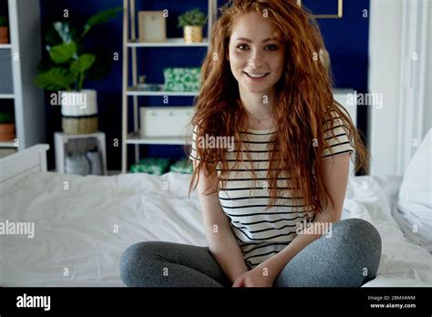 Portrait Of Redhead Woman Sitting On Bed Stock Photo Alamy