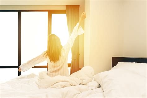 Premium Photo Rear View Of Woman Stretching In Bed After Wake Up In Morning With Sunlight
