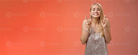 Nervous Hopeful Blond Young Woman In Silver Trendy Dress Close Eyes