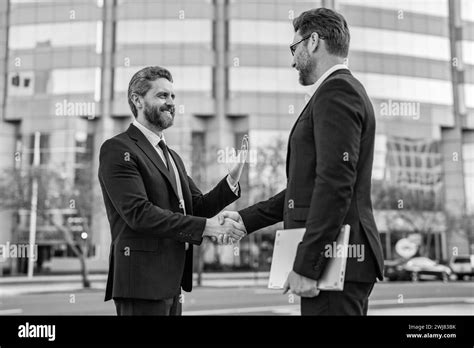 Photo Of Positive Two Business Men Handshaking Two Business Men