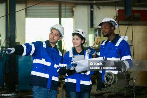 제복을 입은 팀 작업자는 청사진을 들고 안전 브레인스토밍을 하고 있으며 작업 관리는 공장에서 작업 기계를 수행합니다 엔지니어 산업 작업 금속 제품 기계 제조 워크숍에 대한