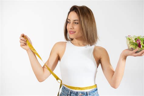 흰색 배경위에 고립 된 샐러드 그릇을 보여주는 측정 테이프를 가진 젊은 여성 건강한 생활방식에 대한 스톡 사진 및 기타 이미지 건강한 생활방식 건강한 식생활 미소