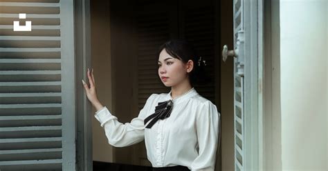 흰 블라우스를 입은 여자가 창밖을 내다보고 있다 사진 Unsplash의 무료 베트남 이미지