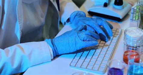 Scientist Wearing Gloves Works At A Computer In A Laboratory Stock