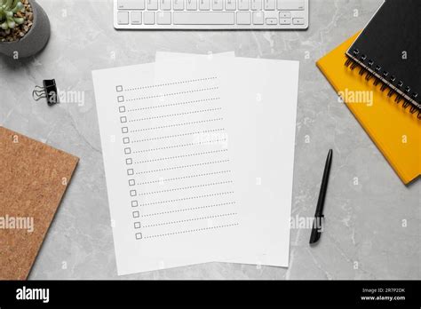 paper sheet with checkboxes plant and computer keyboard on light grey
