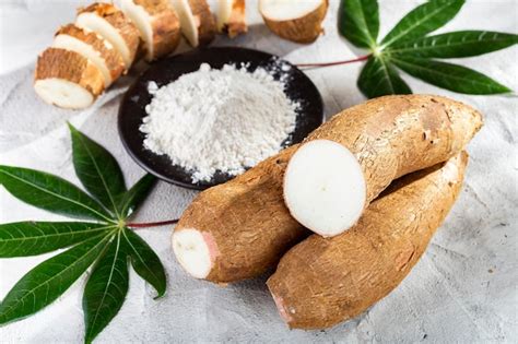 Premium Photo Pile Of Cassava Root And Cassava Flour On A Gray And White Textured Background