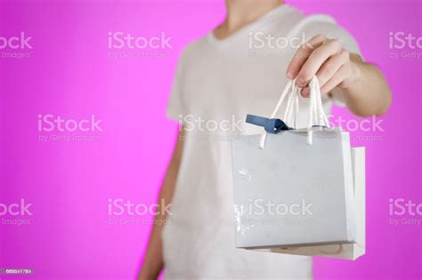 손으로 들고 있는 남자는 두 개의 종이 선물 가방을 모의로 두 개 들고 있었다 빈 패키지 모형은 격리 된 손에 잡습니다 로고 디자인 또는 아이덴티티 프리젠 테이션을위한