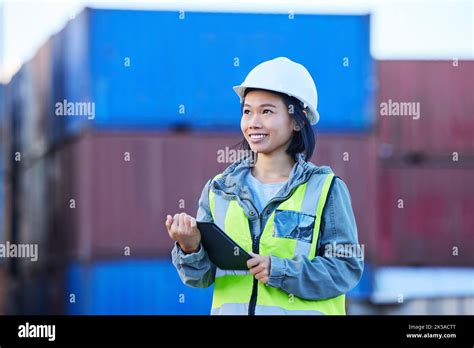 Cargo Logistics And Shipping Employee With Tablet For Digital Checklist On Container Port For