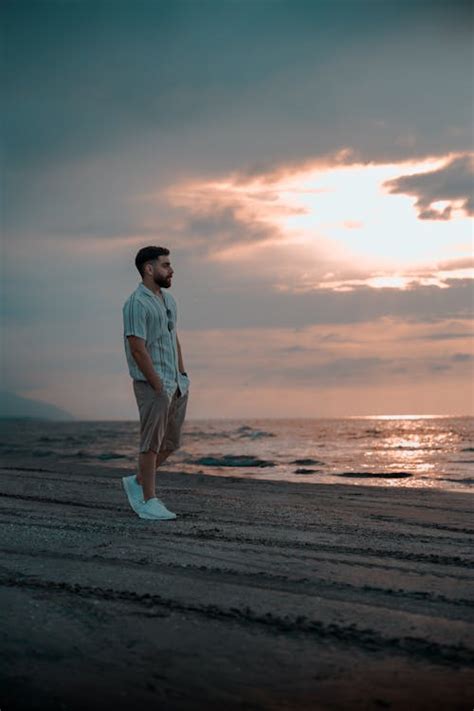 고독 바다 반바지 보고 있는 서 있는 셔츠 수직 쐈어 외로움 젊은 남자 주머니에 손을 넣다 해변 해안선