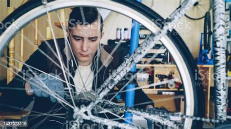 집중된가 숙련 된 기계공 그의 직장에서 일 하는 Wrenchwhile와 함께 자전거 바퀴를 수리입니다 자전거 정비 사람과 직업 개념입니다 기계공에 대한 스톡 사진 및 기타