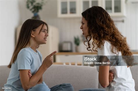 집에서 어머니와 싸우는 감정적 인 십 대 소녀 딸 소파에 서로 앞에 앉아 언쟁에 대한 스톡 사진 및 기타 이미지 언쟁 십대