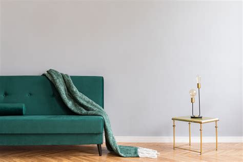 녹색 벨벳 디자인 소파 커피 테이블 및 우아한 담요에 테이블 램프와 함께 럭셔리 홈 인테리어 비문에 대 한 공간을 복사 포스터를 조롱 갈색 나무 마루입니다 회색 배경