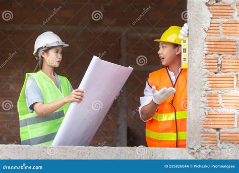 Engineer Concept The Female Constructor Holding The Building Scheme While The Constructing Guy