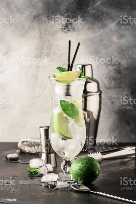 프레쉬 라임 지팡이 보드카 카차사 설탕 시럽 라임 주스 으깬 얼음을 회색 테이블 바 도구 텍스트 장소의 높은 유리에 넣은 브라질 카이피리냐 또는 모히토 알코올 칵테일