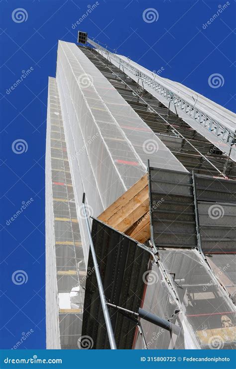 Building Covered In Scaffolding During Installation Of Insulation Panels To Safeguard The