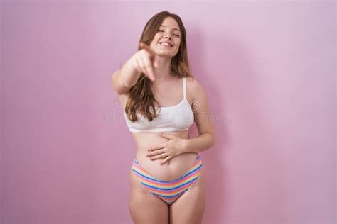 Caucasian Woman Wearing Lingerie Over Pink Background Laughing At You