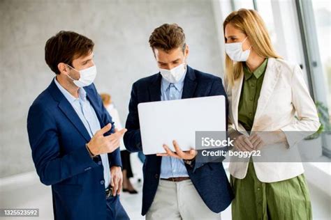 젊은 이들이 그들 뒤에 작동 사무실에서 실내에서 손에 노트북을 들고 서 두 남자와 여자 3 명에 대한 스톡 사진 및 기타 이미지 3 명 30 34세 35 39세