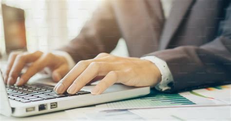 노트북을 작업하는 남자의 측면보기는 아침 햇살이 있는 Conner 사무실의 작업 테이블에 있습니다 사진 Unsplash의