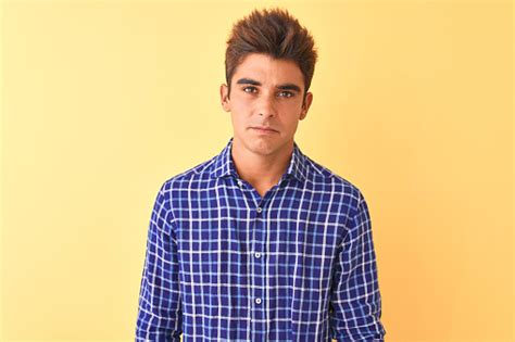 고립 된 노란색 배경 위에 서있는 캐주얼 셔츠를 입은 젊은 잘생긴 남자는 우울하고 고민에 대한 걱정 분노와 두려움을 울고 슬픈 표정 감정에 대한 스톡 사진 및 기타 이미지