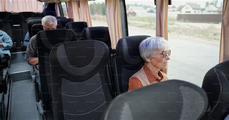 회색 머리를 가진 늙은 백인 여성은 버스 안의 창가에 앉아 도로와 시골집을 보고 있다 사진 Unsplash의 승차 이미지