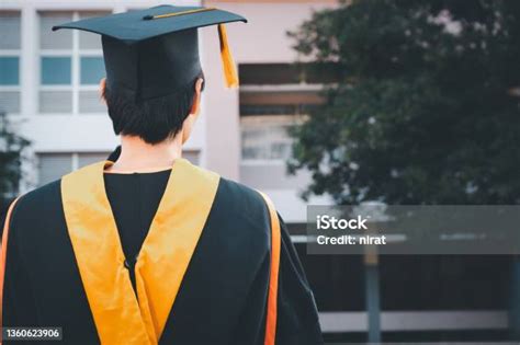 전통적인 가운 옷과 모자를 쓰고 일몰을 손에 들고 기장 졸업장을 들고 서 있는 졸업생 컨셉 교육 축하 졸업식 대학의 졸업생을 축하했다 졸업식에 대한 스톡 사진 및 기타