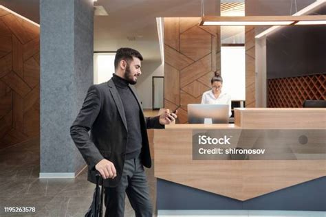 호텔 라운지에서 스마트폰으로 여행 가방을 스크롤하는 젊은 비즈니스 여행객 2명에 대한 스톡 사진 및 기타 이미지 2명 경영자 기업 비즈니스 Istock