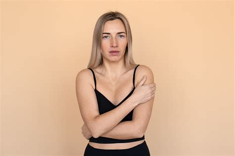 베이지색 배경 위에 서 있는 관계의 개인적인 문제에 대해 생각하는 슬픈 젊은 여성의 초상화 생각에 빠진 화가 난 소녀 외로움을 느낀다 우울하다 숙고 또는 애도 30 34세에