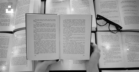 블랙 프레임 안경을 쓴 책 페이지를 들고 있는 사람 사진 Unsplash의 무료 회색 이미지