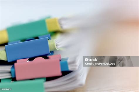 Close Up Pile Of Unfinished Paperwork On Office Desk Waiting To Be