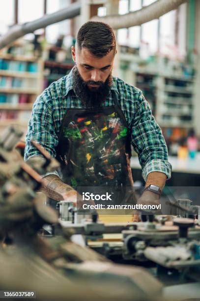 작업장에서 인쇄기를 사용하는 동안 프레임에 잉크를 누르는 남성 노동자 실크 스크린에 대한 스톡 사진 및 기타 이미지 실크