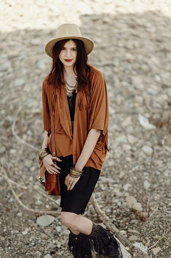 모자 가죽 가방 프린지 판 쵸와 부츠와 함께 아름 다운 세련 된 Boho 여자 소식통 여자 집시 히피에 젊은 여행자 강 바위 산에 가까운 포즈 봐 관능적인 보세요입니다 대기