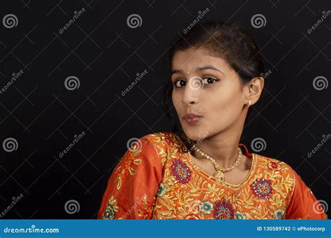 Ritratto Di Giovane Ragazza Indiana Felice Che Increspa Le Sue Labbra Su Fondo Nero Fotografia