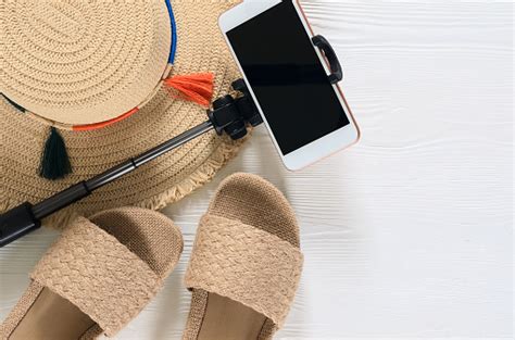 여자는 흰색 나무 배경 액세서리와 샌들 여름 패션 여행 컨셉 보세요 플랫이 하다 천연 유기 재료 Monopod에 대한 스톡 사진