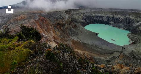 낮에는 흰 구름 아래 푸른 바다 옆의 갈색과 녹색 산 사진 Unsplash의 무료 화산 이미지