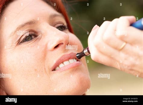 Portrait Of A Pretty Redhead Woman Smoking A Electronic Cigarette In A