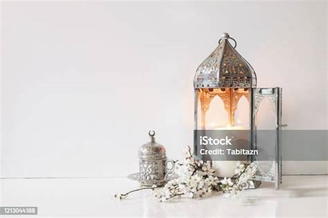 차 흰색 꽃 가지 치기 나무 꽃과 테이블 배경에 빛나는 모로코 랜턴의 실버 장식 컵 이프타르 저녁 식사 라마단 카림 인사말 카드 초대장 이드 울 피터 무슬림 휴가 라마단에