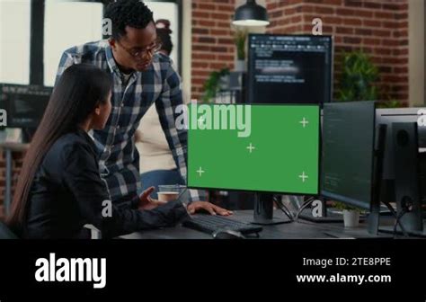 mixed team of programmers analyzing source code looking at green screen