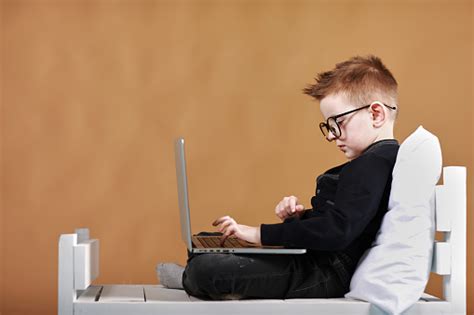 침대에 앉아 노트북을 사용하여 안경에 여학생 학교 숙제를하는 아이 온라인 학습 거리 수업 가정 격리에서 온라인 튜터와 교육 6 7 살에 대한 스톡 사진 및 기타 이미지