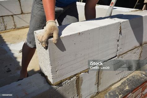 건축 업자는 역청 아스팔트 방수 멤브레인이 설치된 벽돌 기초 위에 자동 화격자 처리 콘크리트 블록을 거짓말 벽을 구축하고 있습니다 미국에 대한 스톡 사진 및 기타 이미지