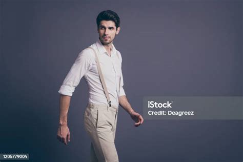 매력적인 화려한 남자 산책 응시 카피 스페이스의 프로필 측면 사진은 회색 색상 배경 위에 고립 된 세련된 의류를 착용하는 여성을 유치 갈색 머리에 대한 스톡 사진 및 기타