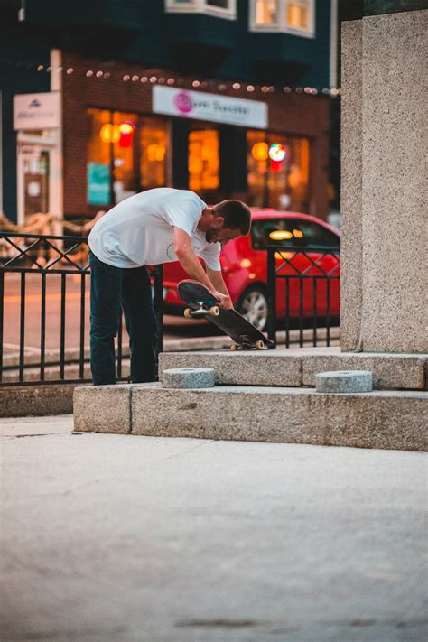 흰색 드레스 셔츠와 검은 바지를 입은 남자가 낮 동안 회색 콘크리트 바닥에 서 있다 사진 Unsplash의 무료 사람 이미지