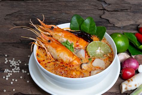 톰 얌 궁 또는 새우 수프 매운 새 수프 태국의 전통 음식은 상단 보기에서 오래 된 나무 배경에 흰 접시에 밥과 함께 칠리 라임 레몬그라스 라임 잎을 포함 합니다 0명에